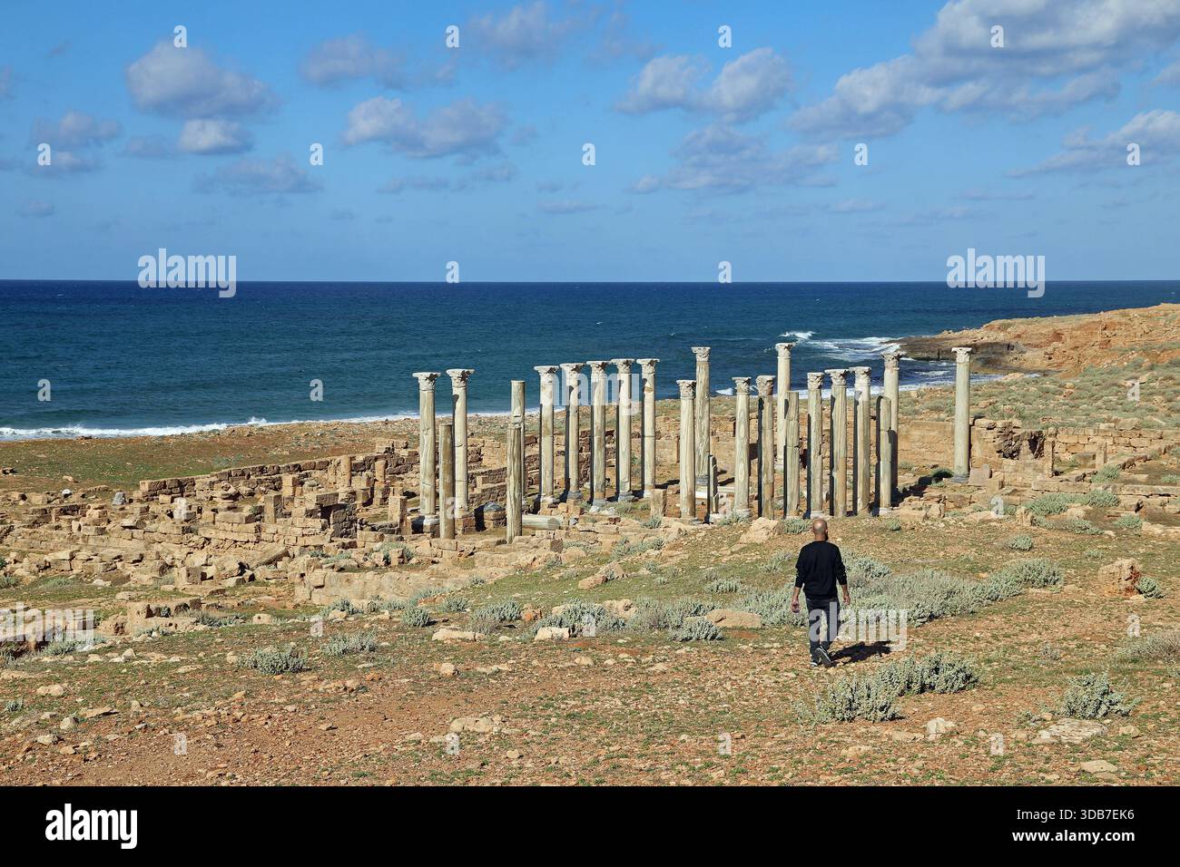 Tourist walking towards ancient marble columns at Apollonia in East ...
