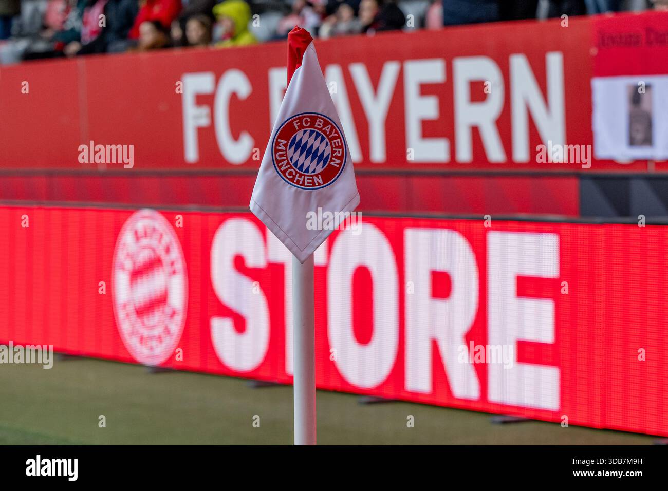 Corner flag with the logo of FC FC Bayern Munich, behind an LED banner ...
