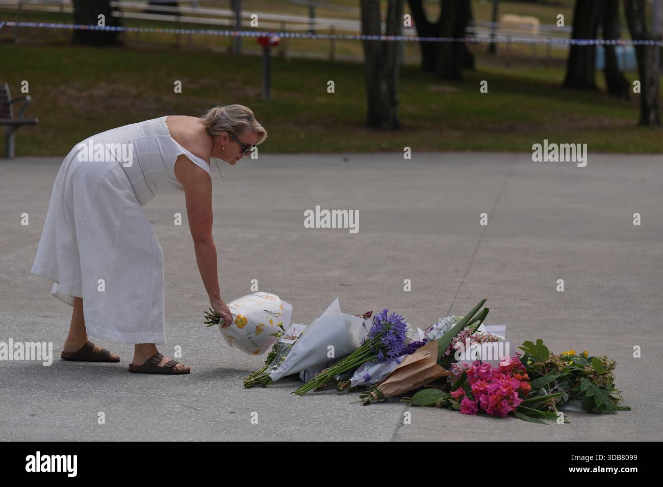A woman lays flowers down at a memorial at Sydney's Bondi Pavilion, Monday, Dec. 15, 2025, a day ...