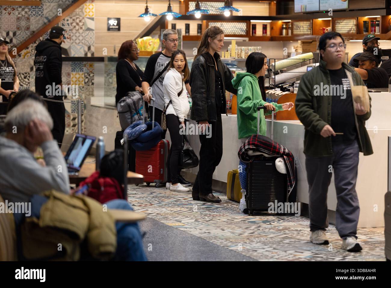 Passengers sit and dine at Urth Caffé & Bar inside a terminal at Los ...