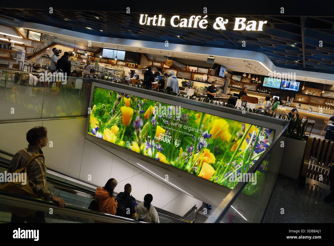 Passengers sit and dine at Urth Caffé & Bar inside a terminal at Los ...