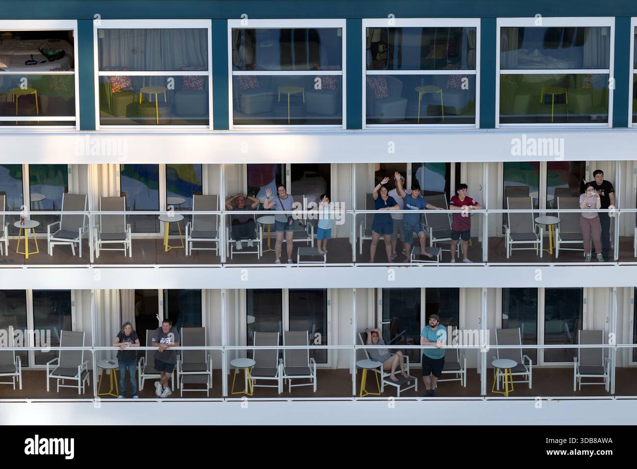 Passengers stand on private balconies and cabin windows aboard a cruise ...