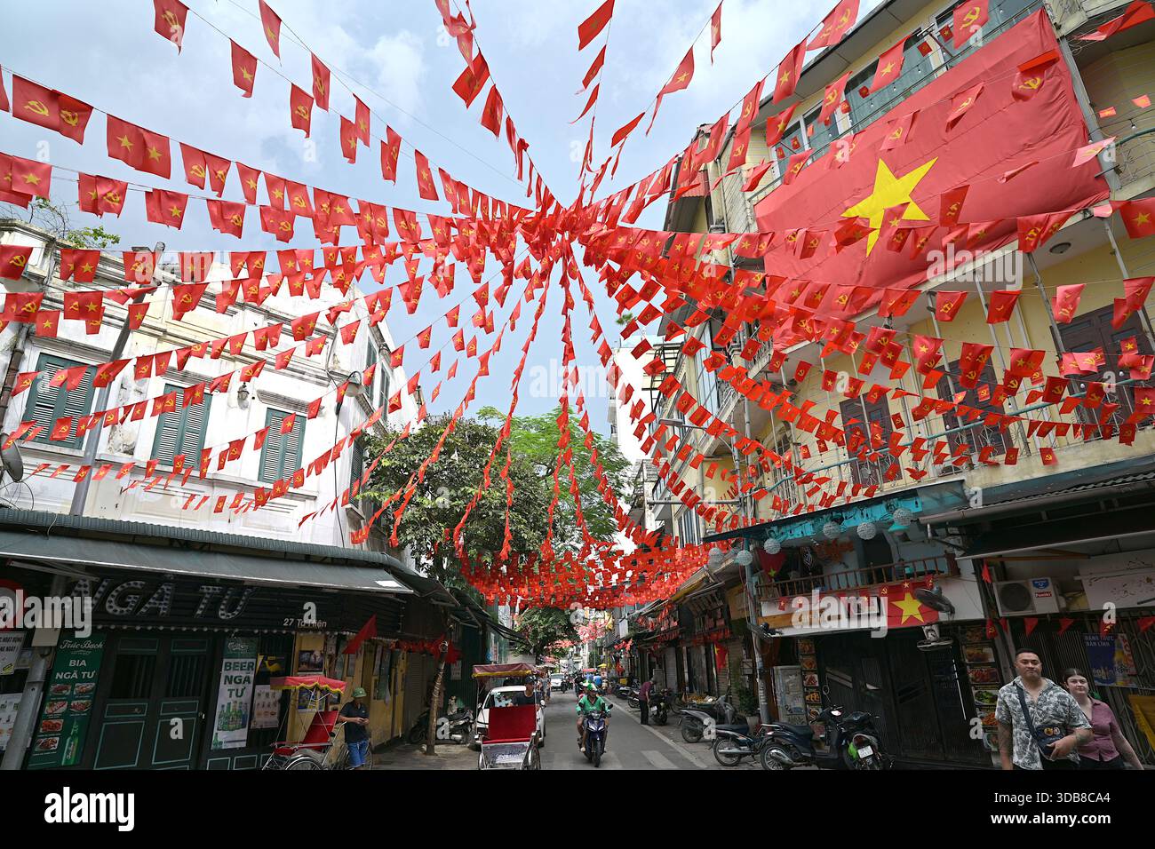 The National and Communist Party flags of Vietnam lining the narrow ...