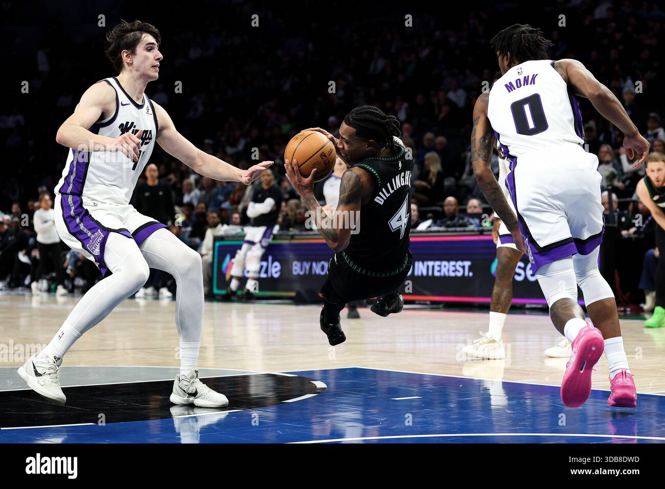 Minnesota Timberwolves guard Rob Dillingham, center, trips as he drives ...