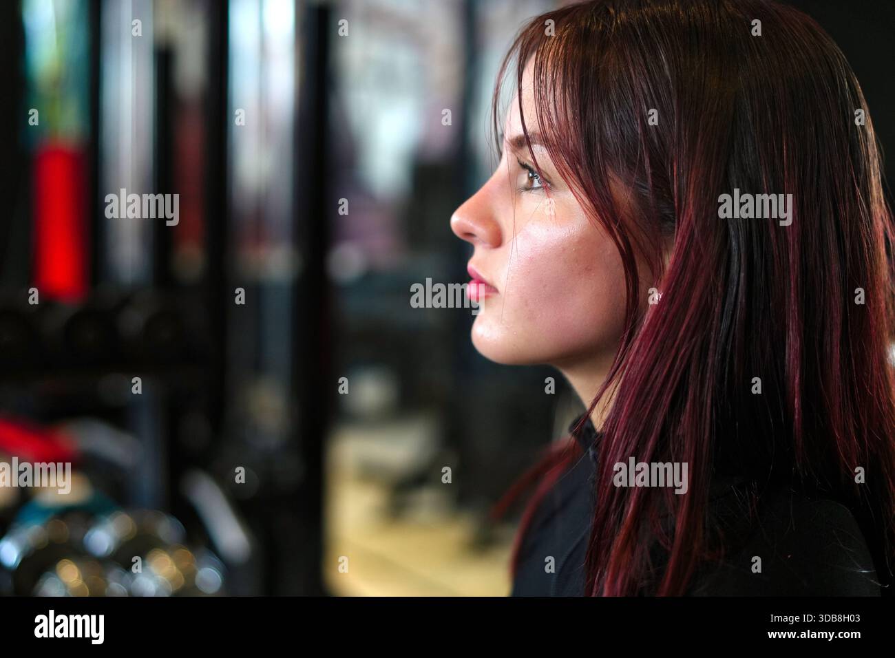 Woman in profile concentrating with intense determination during a gym ...