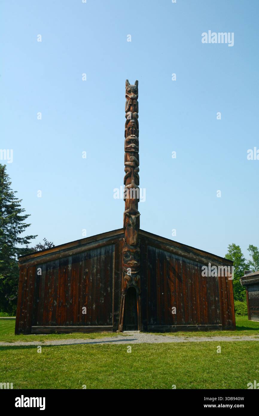 Totem pole and decorated wooden house at the Ksan Historical Village, a ...