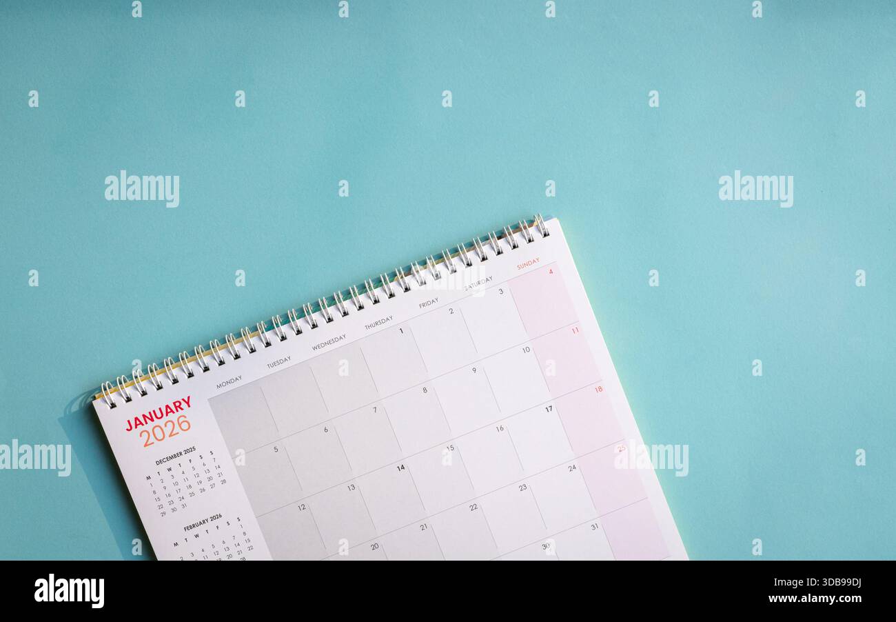 2026 table calendar with January 2026 page on top of light blue plain ...