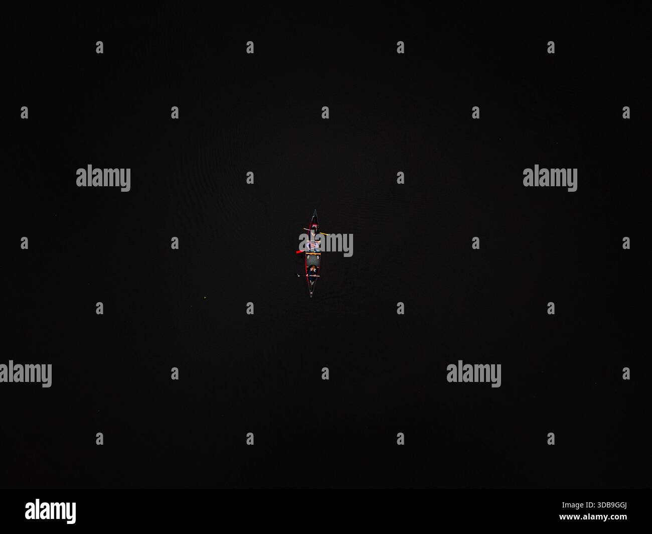 Aerial view of a solitary boat cutting through the inky blackness ...