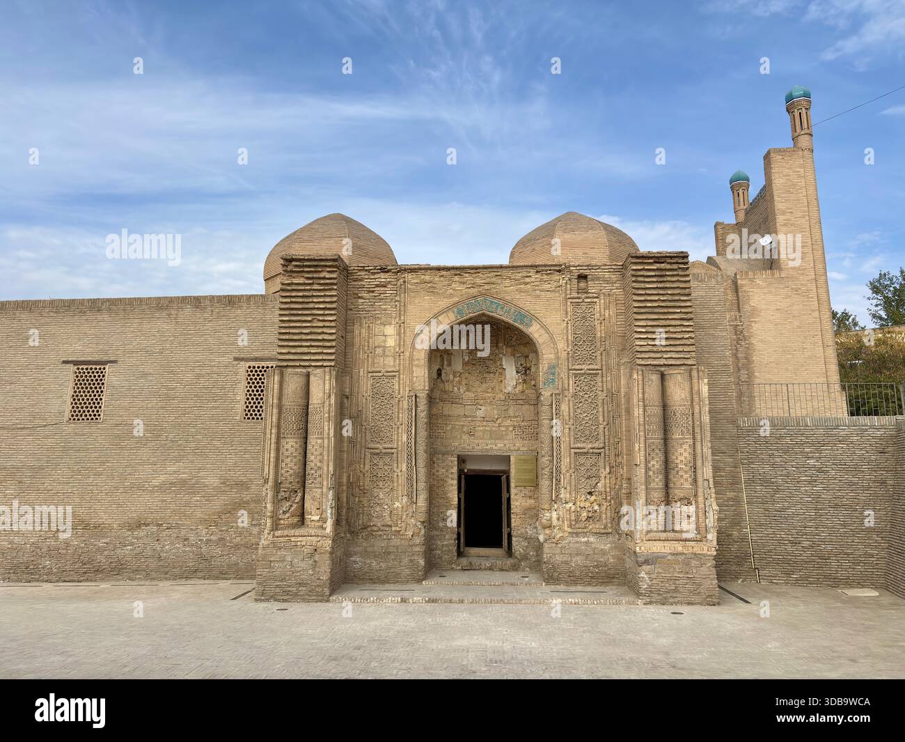 Ancient brick madrasah portal w/ twin domes & tall minaret structure ...