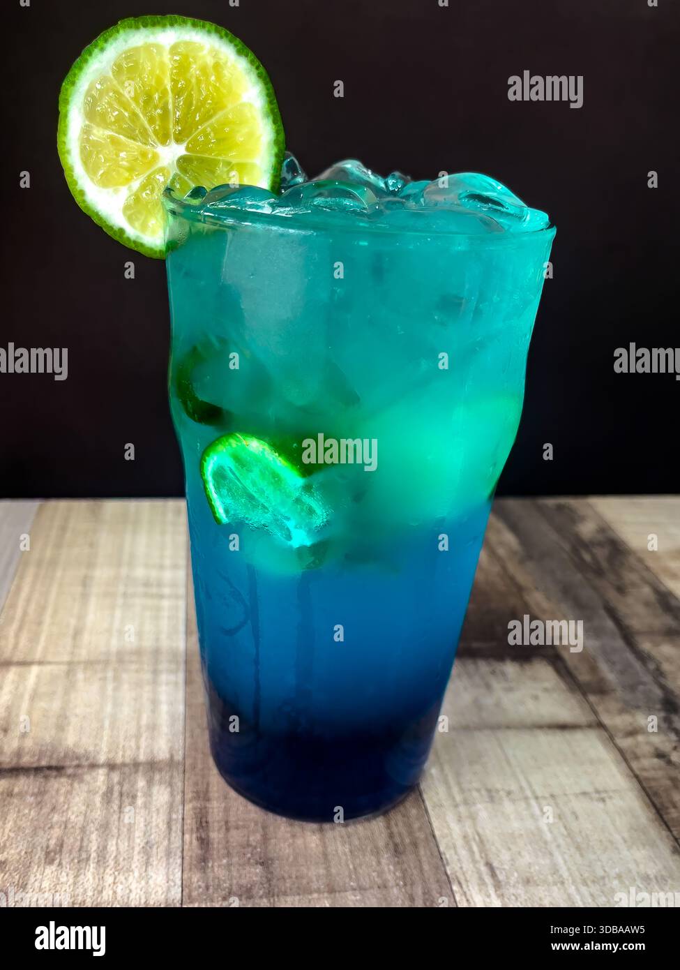 blue lagoon mocktail served in a tall glass with ice cubes and fresh ...