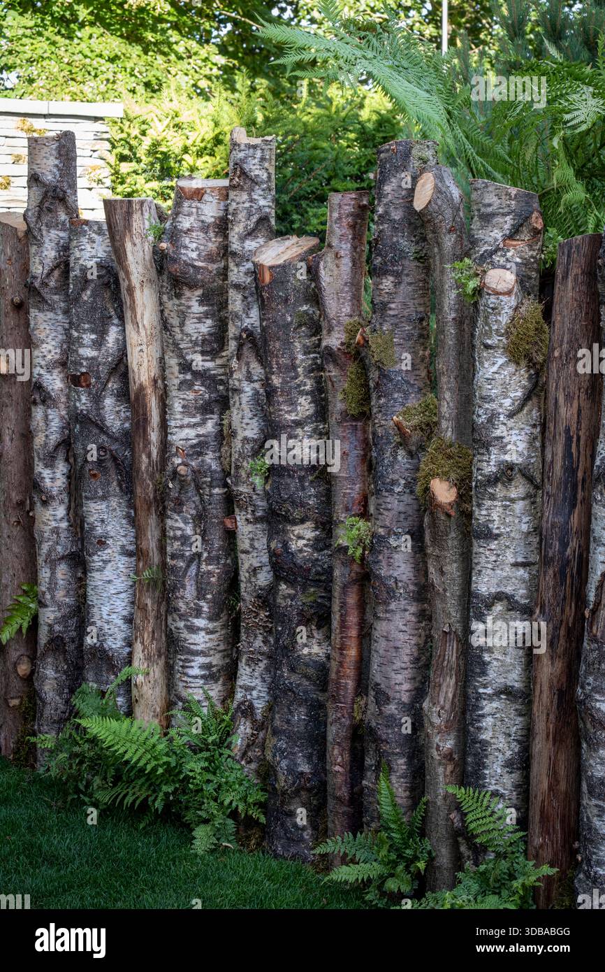 Rustic log wall in garden Stock Photo - Alamy