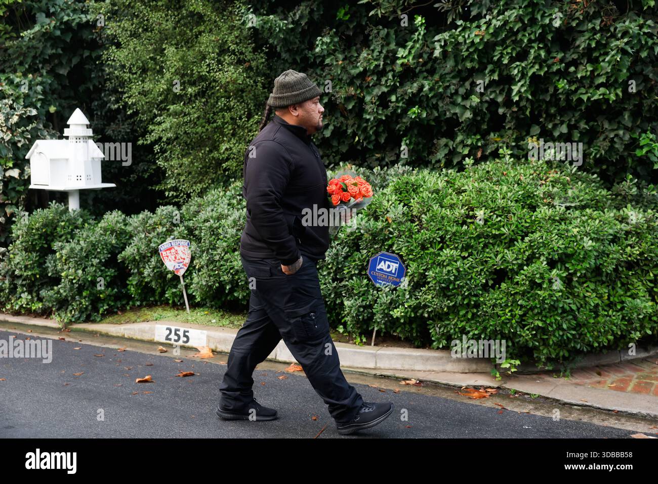 A well-wisher drops a bouquet of flowers in front Rob Reiner's ...
