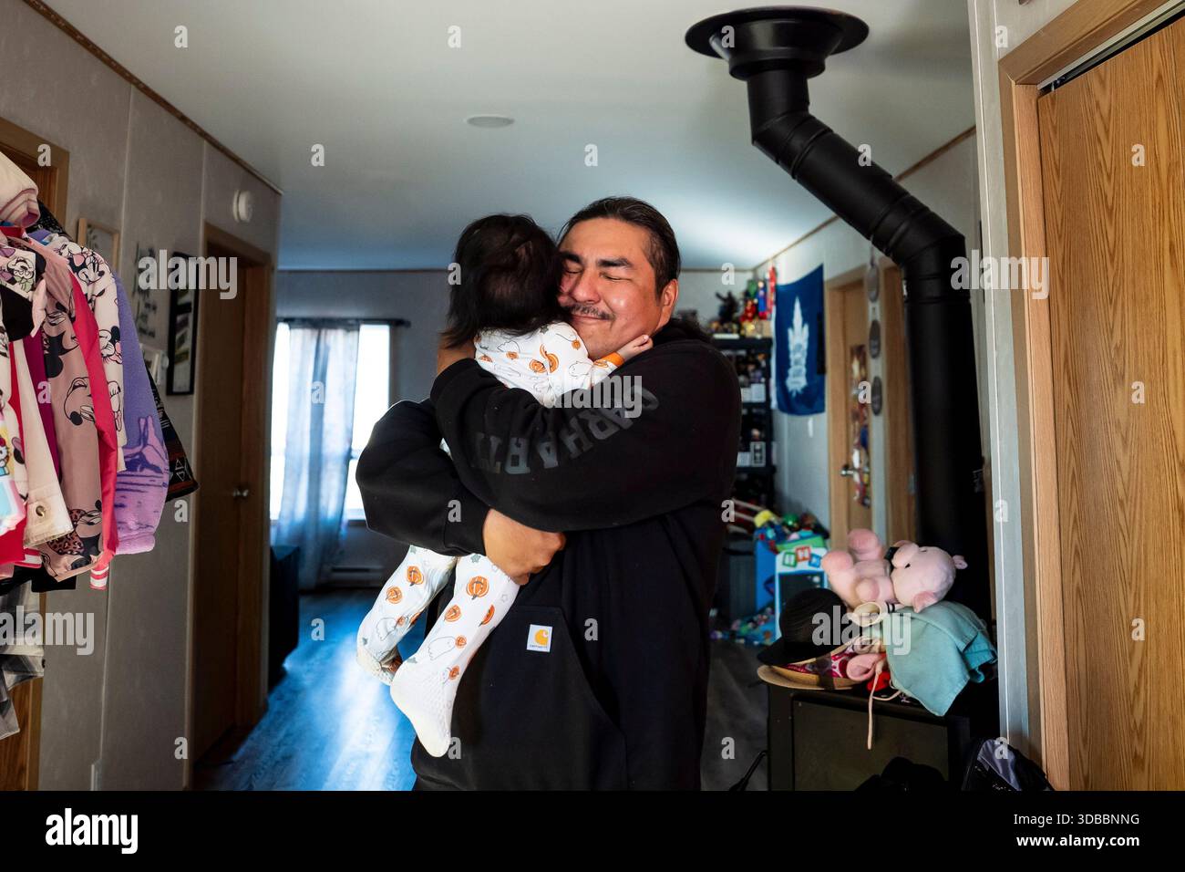 Ryan Moonias hugs his eight-month-old daughter, Millie, at his home in ...