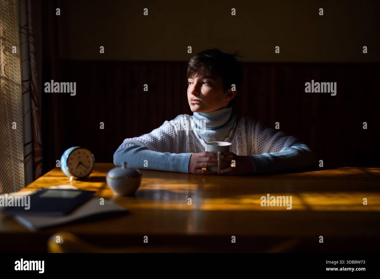 Sad orphan girl sitting alone at table. Poverty concept Stock Photo - Alamy