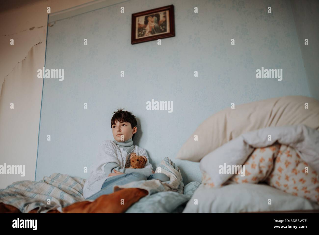Sad orphan girl sitting alone in bedroom. Poverty concept Stock Photo ...