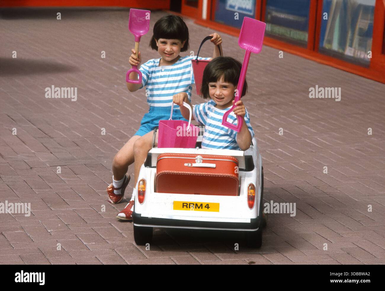 Identical twins Sarah and Alison in battery powered toy Rolls Royce ...