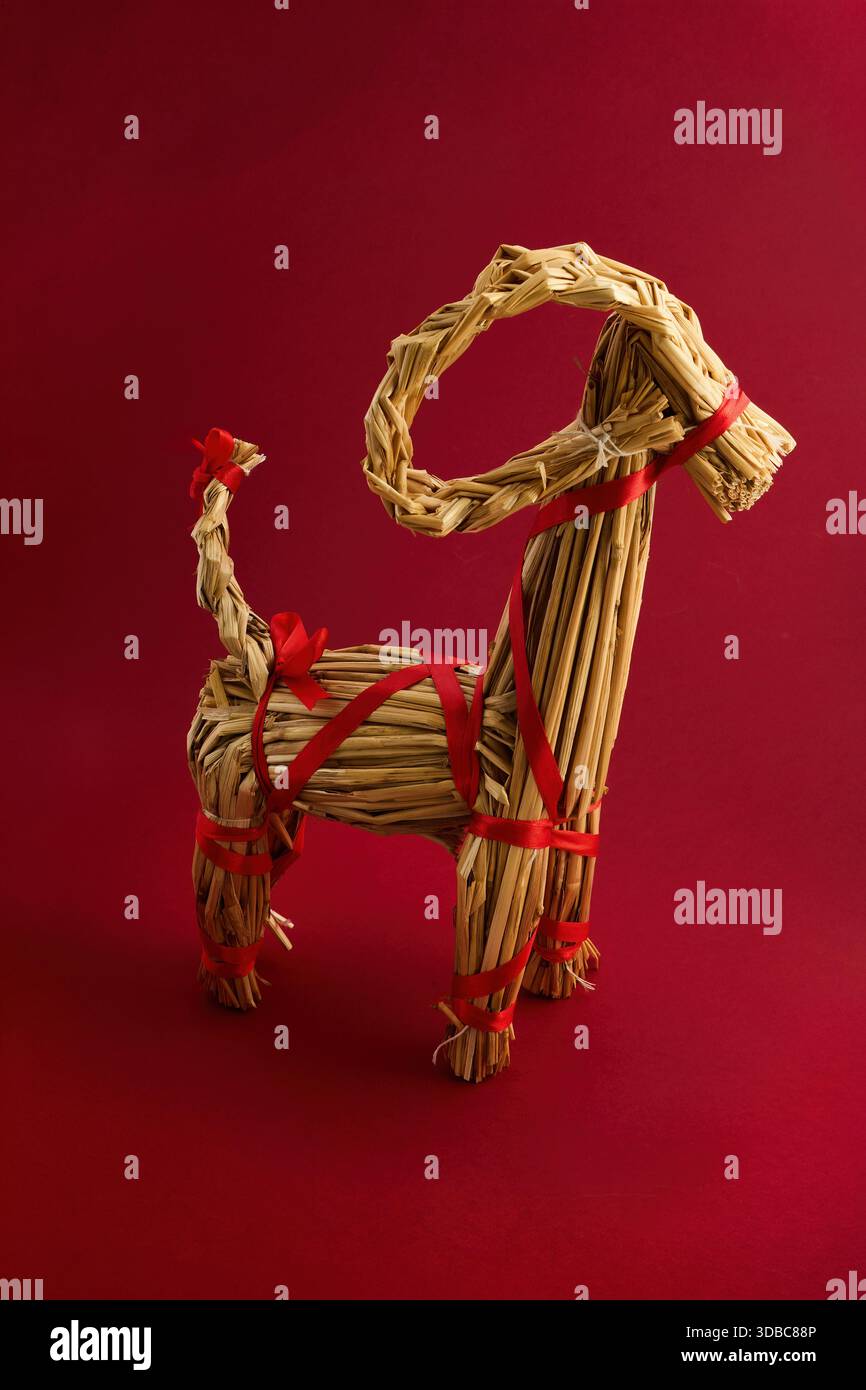 Straw Goat Sculpture. A straw goat sculpture with red ribbons against a ...