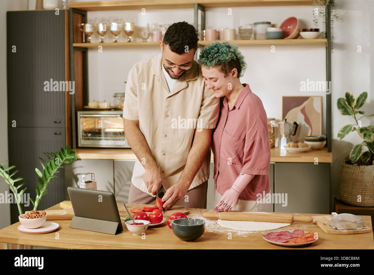 Young Woman with Prosthetic Arm Cooking with Young Man Stock Photo - Alamy