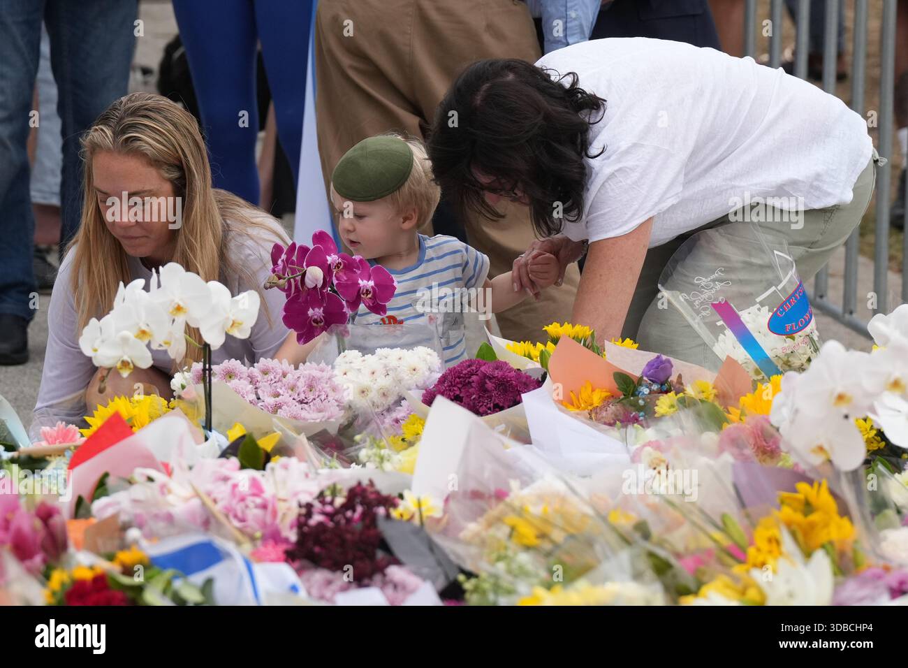 A child places flowers at a memorial at Bondi Beach on Tuesday, Dec. 16 ...