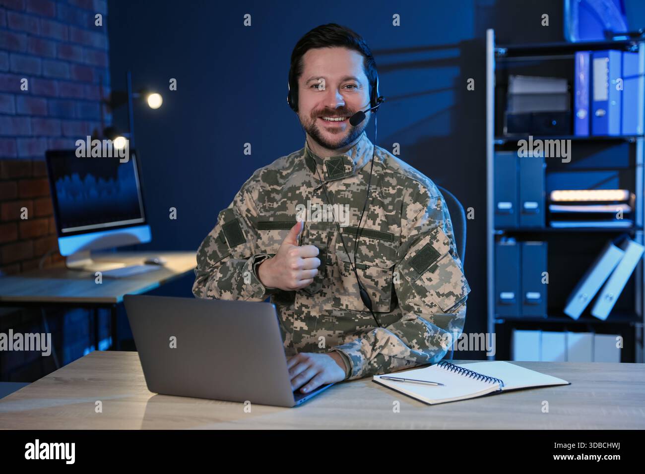 Military man showing thumbs up at wooden desk in office at night Stock ...