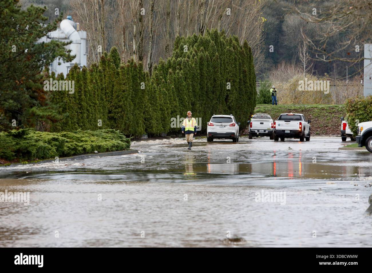 A response team crew member walks by standing water from a levee breach ...