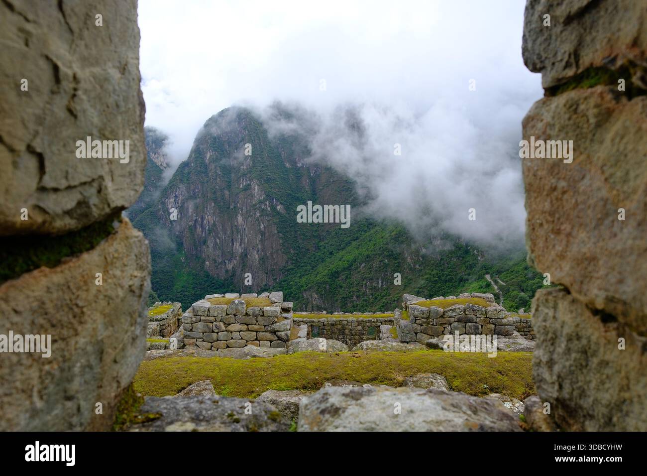 Stone ruins of Machu Picchu framed by ancient walls with misty Andean ...