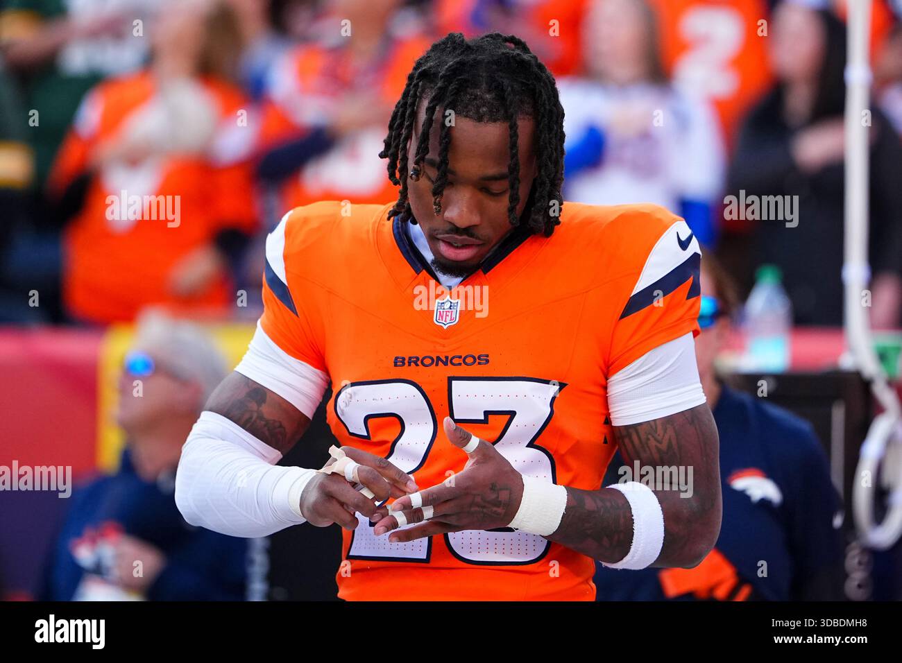 Denver Broncos cornerback Jahdae Barron (23) works on the tape on his ...