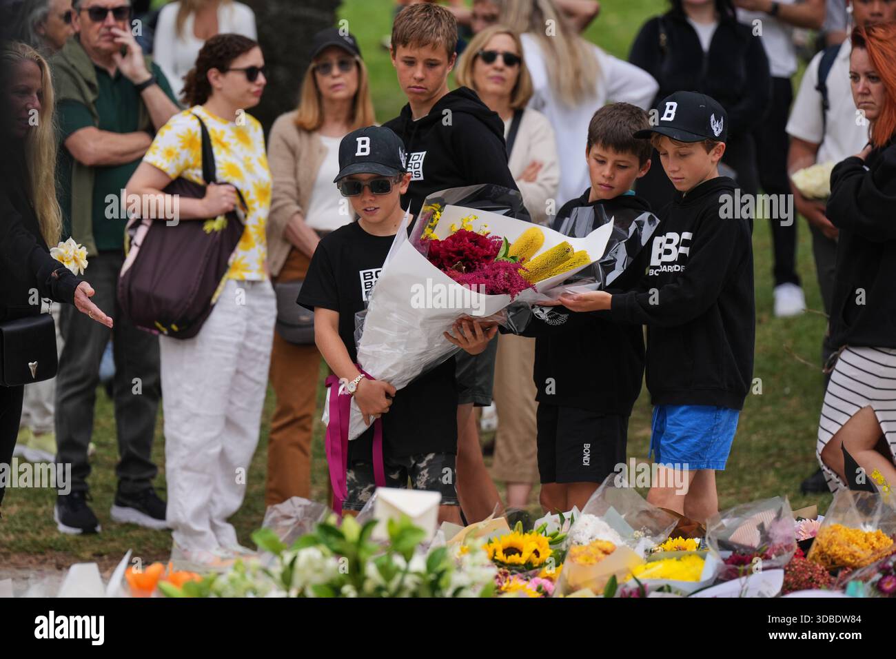 Boys lay flowers at a flower memorial for victims of Sunday's shooting ...