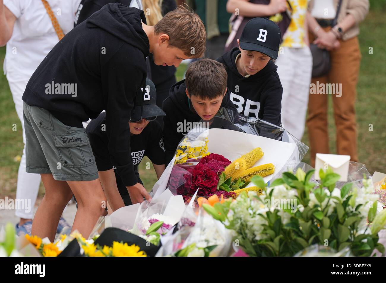 Boys lay flowers at a flower memorial for victims of Sunday's shooting ...