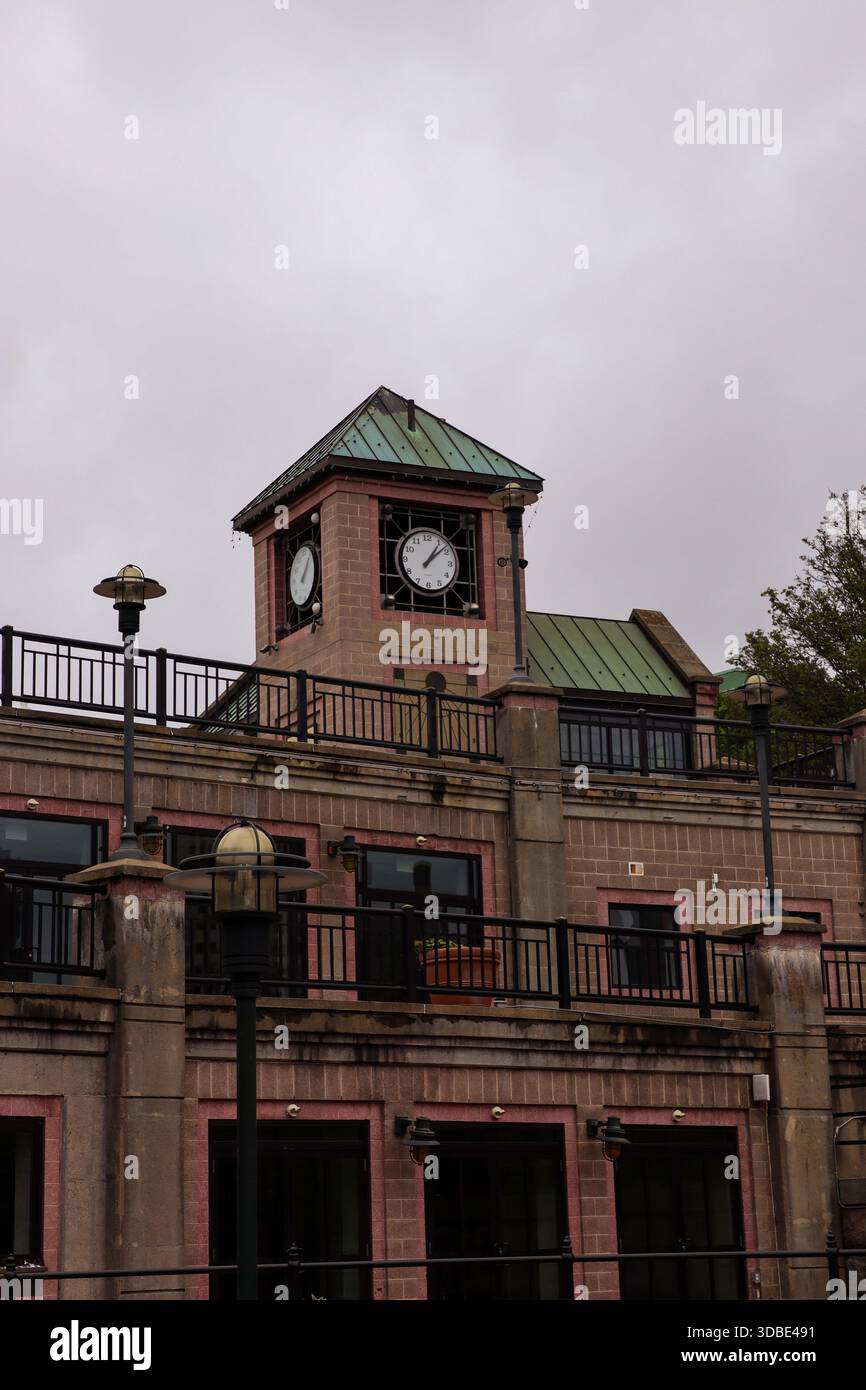Historic-style clock tower with green roof on multi-level urban ...