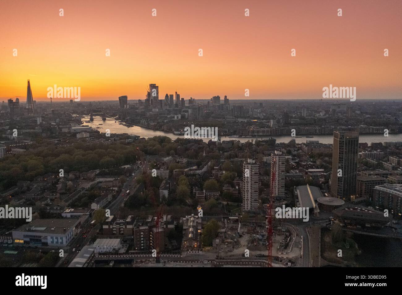 Aerial view of the cityscape paints a vibrant sunset over the Thames ...