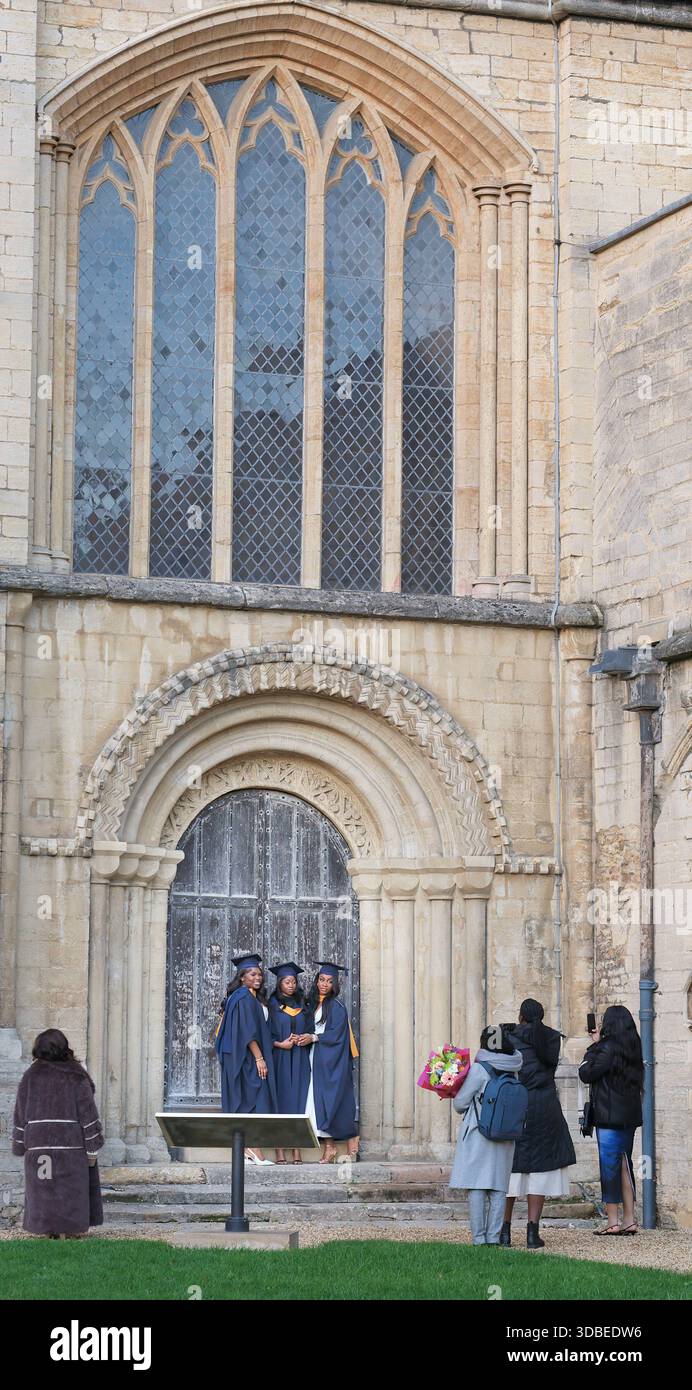 A trio of women students pose for a photograph in the cloisters after ...