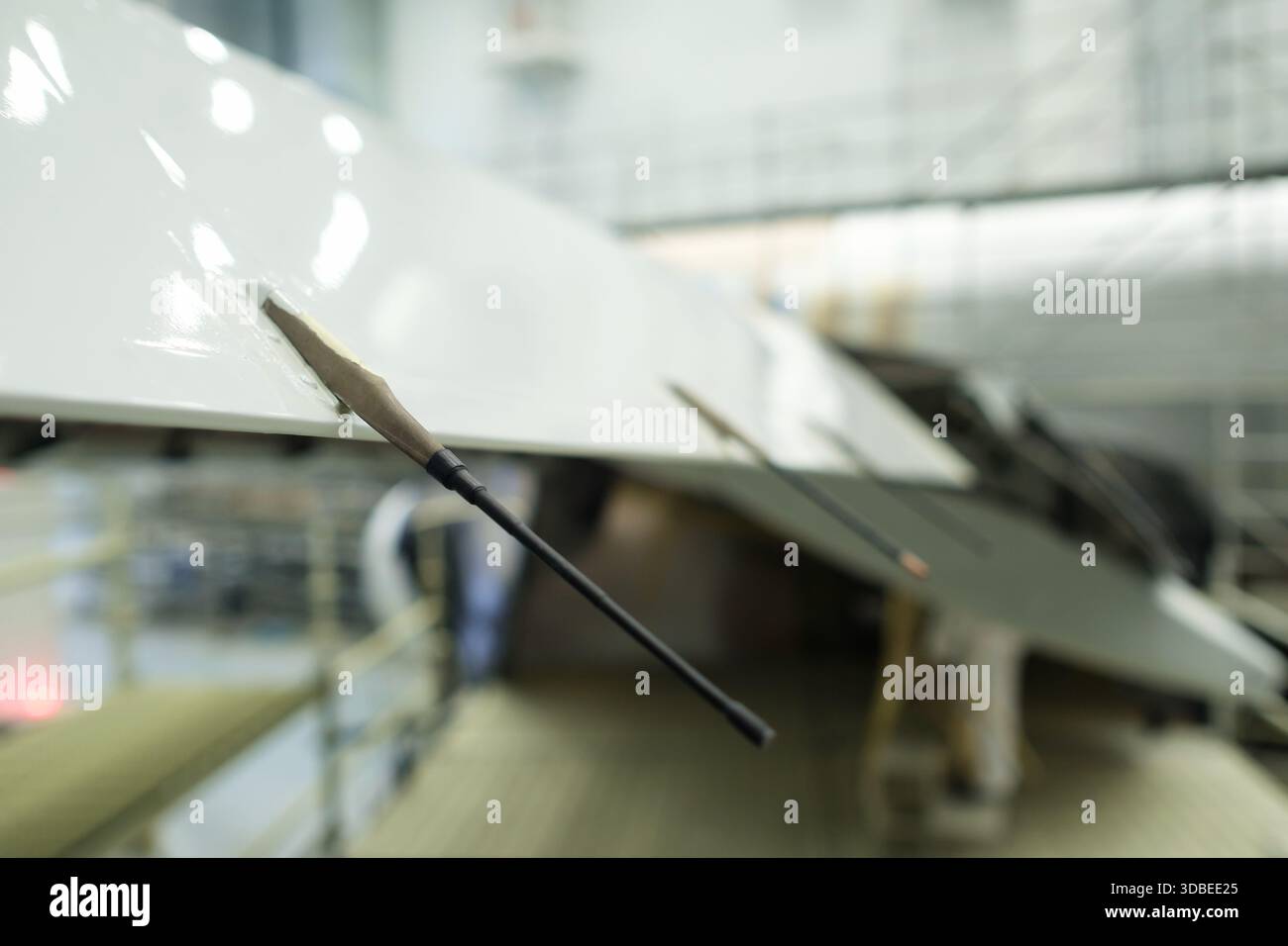 Engineers meticulously inspect the wing of an aircraft, using precision ...