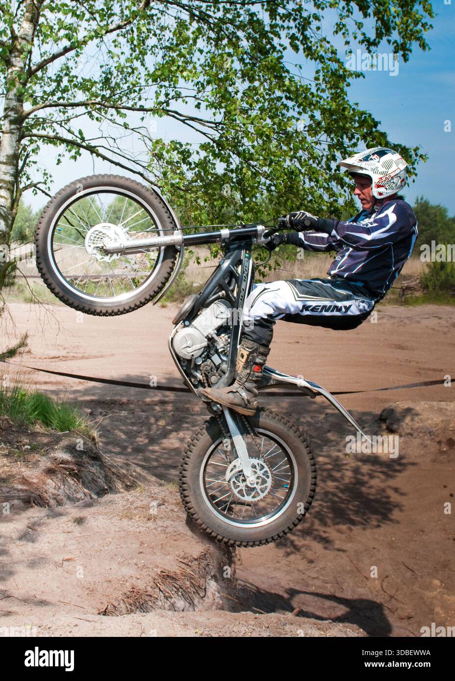 Motocross rider jumps over an obstacle with a Montesa Cota 4RT trial ...