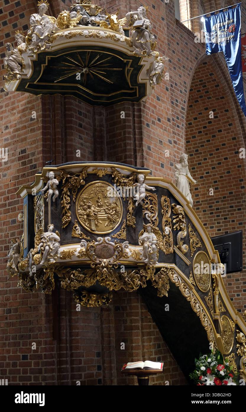 Side view of a richly decorated Baroque pulpit with gilded sculptures ...