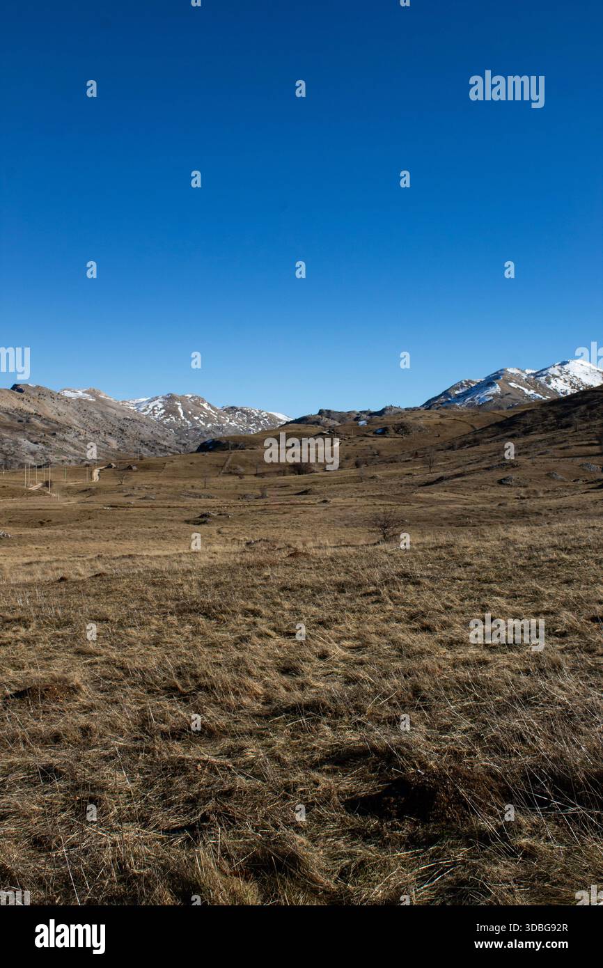 Wide view of an open mountain plateau with dry grassland and distant ...