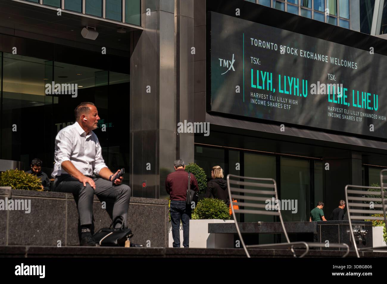 Une personne est assise devant le TMX Market Centre à Toronto, le 11 ...