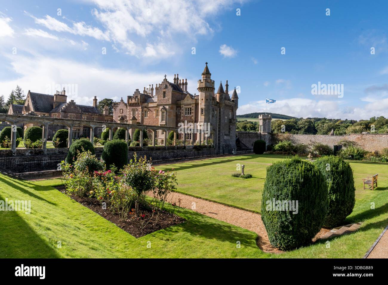 A grand Scottish estate with ornate stone buildings, lush lawns, and ...