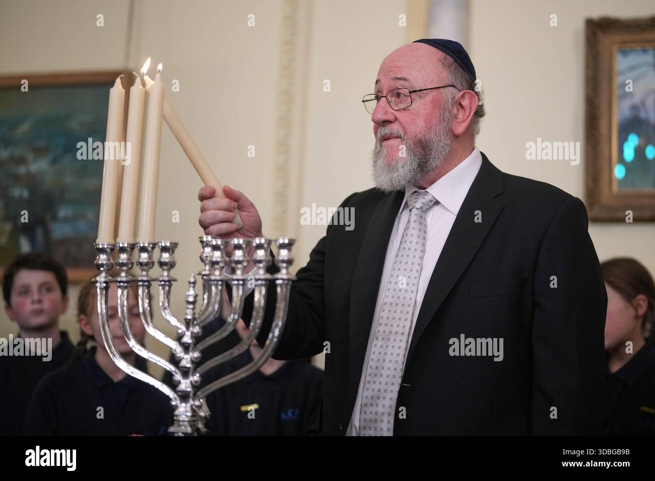 Chief Rabbi Sir Ephraim Mirvis lights a candle during a reception at ...