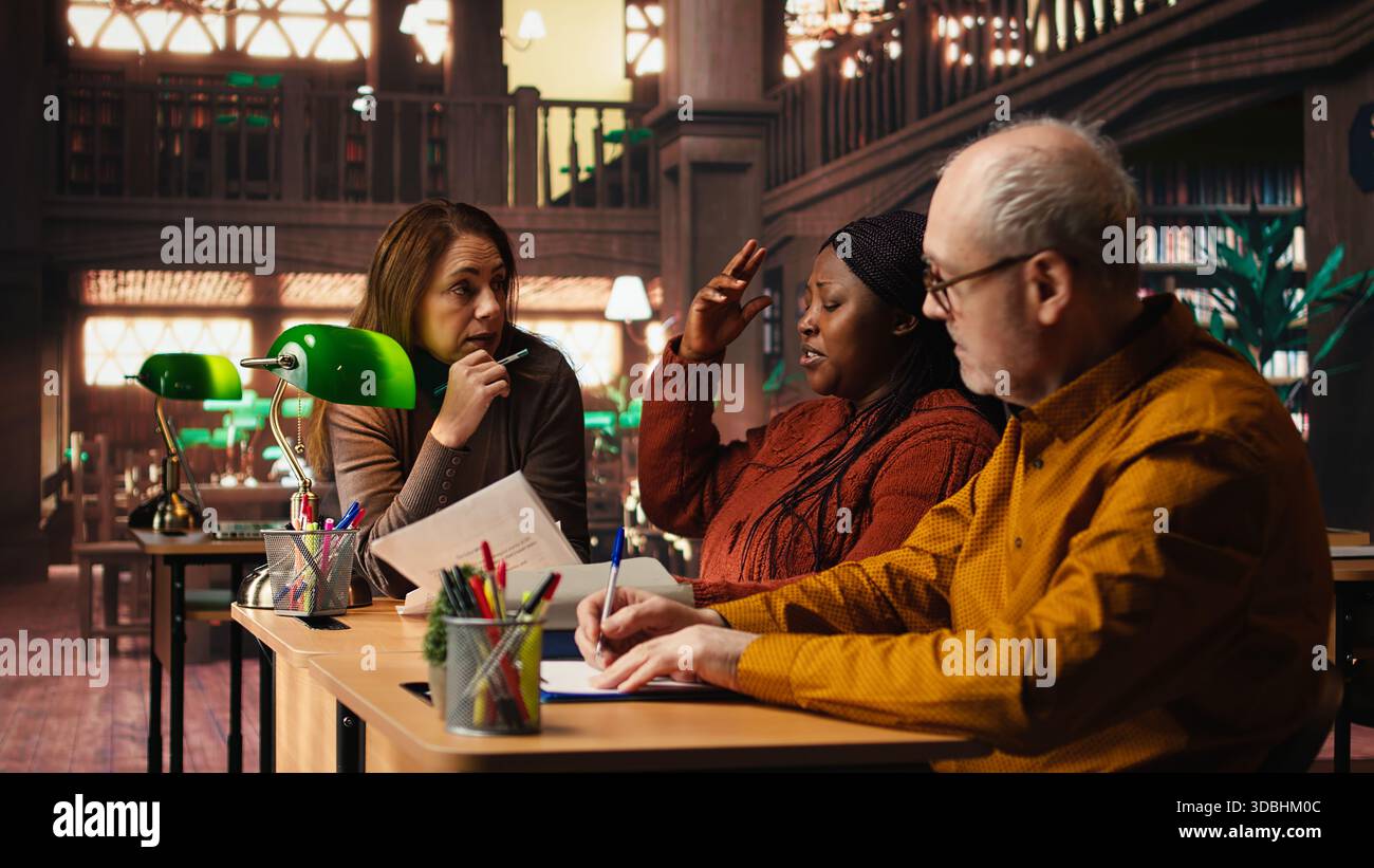 Mature performers engaged in drama rehearsal at the library, focused on ...