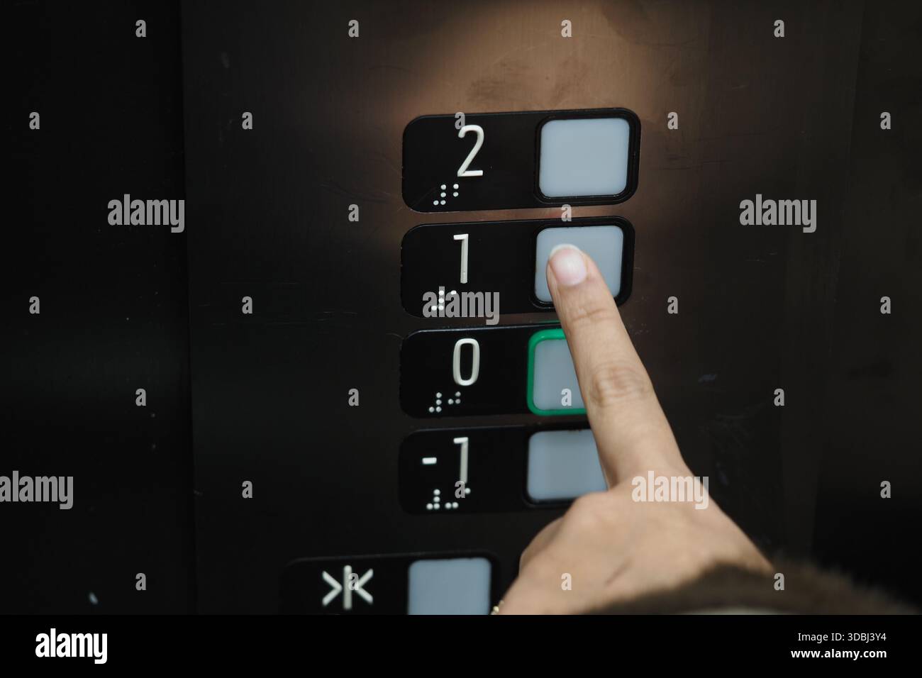 Finger presses elevator button to go to first floor Stock Photo - Alamy