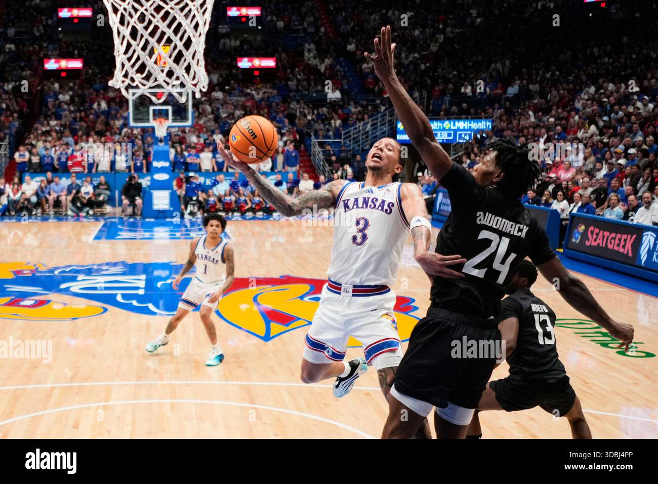 Kansas guard Tre White (3) gets past Towson guard Jaquan Womack (24) to ...
