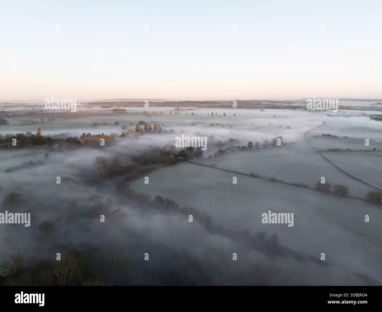 Aerial view of a serene landscape shrouded in a cool, ethereal mist ...