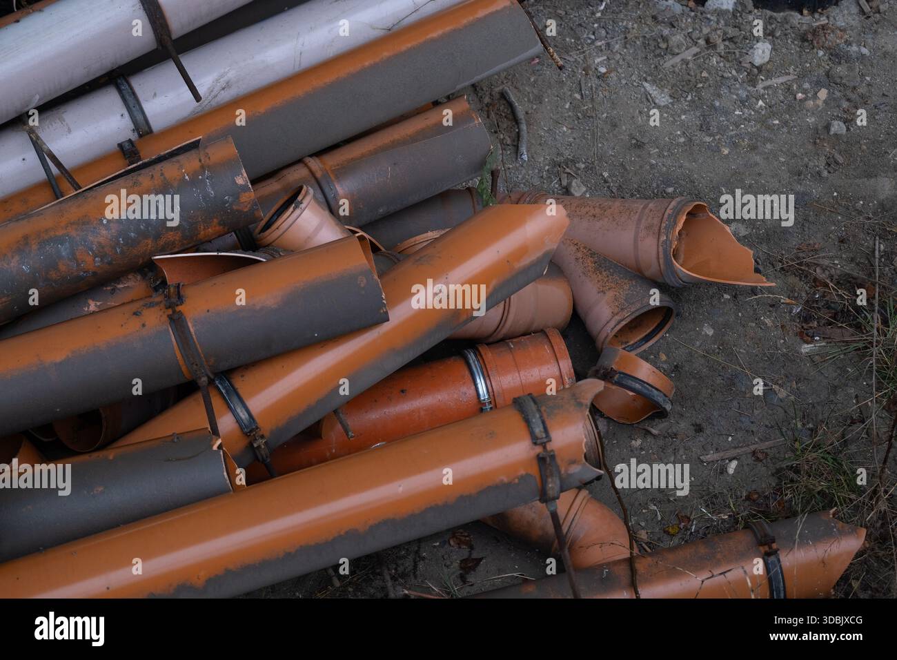 Pile of damaged sewer and drainage pipes lying on the ground after ...