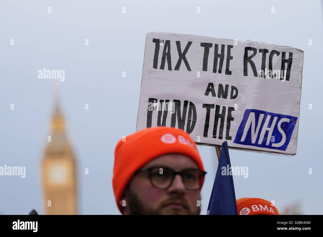A resident doctor holds a banner on the picket line near St Thomas ...