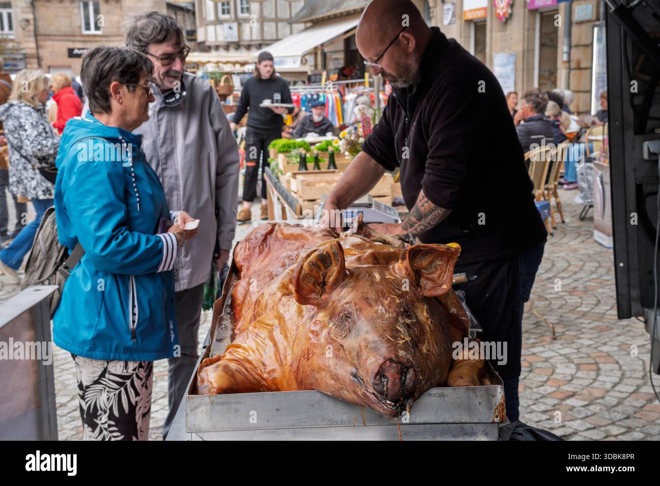 A market stall selling pork carved from a whole roasted pig, Paimpol ...