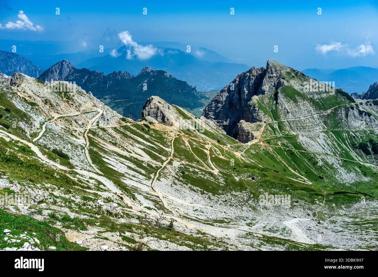 Wide panoramic view of an alpine landscape featuring multiple hiking ...