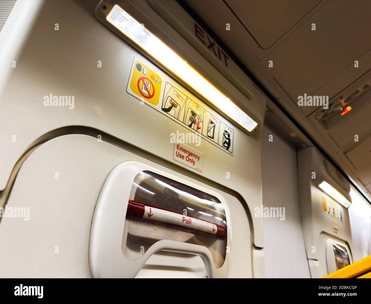 Inside the airplane cabin showing emergency exit signs and a pull ...