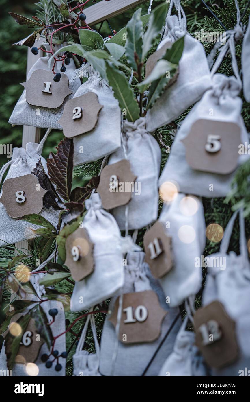 Close-up of homemade advent calendar with linen bags in a wooden frame ...