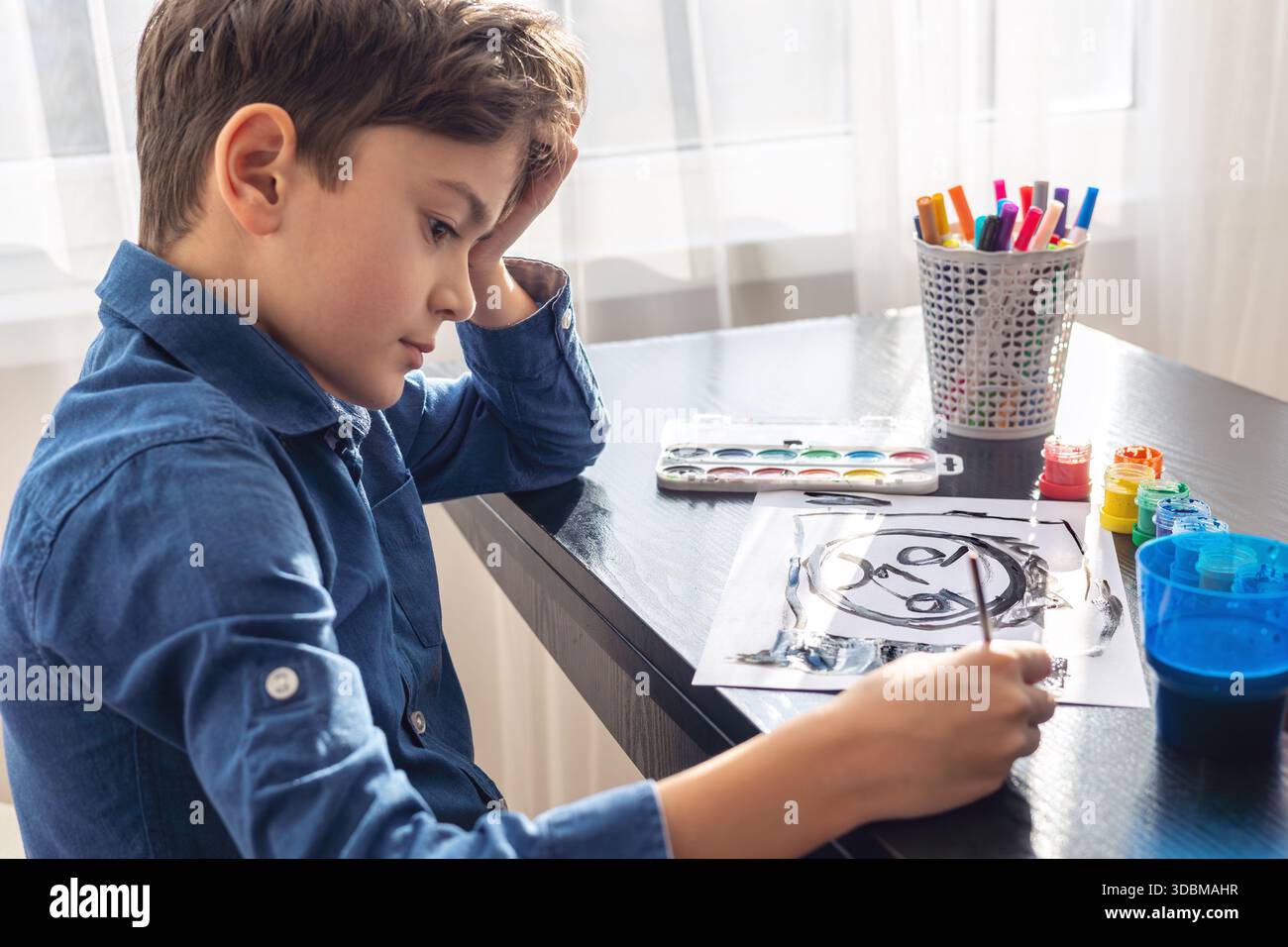 Sad boy painting only in black, expressing emotions through art. Child ...